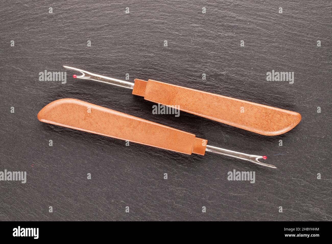 Two sewing knives for cutting threads on a slate stone, close-up, top ...