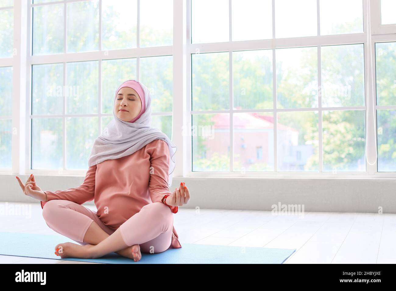 Young pregnant Muslim woman meditating on mat in gym Stock Photo - Alamy