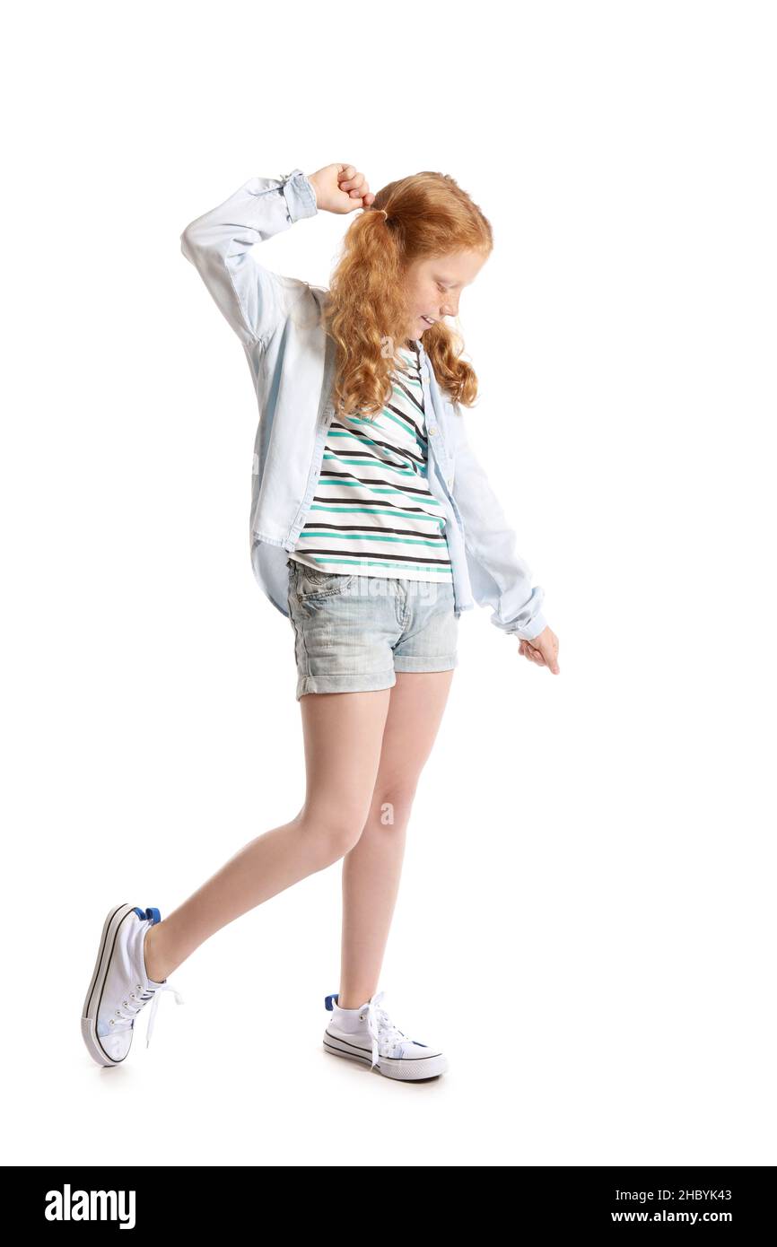 Little redhead girl with ponytails dancing on white background Stock ...