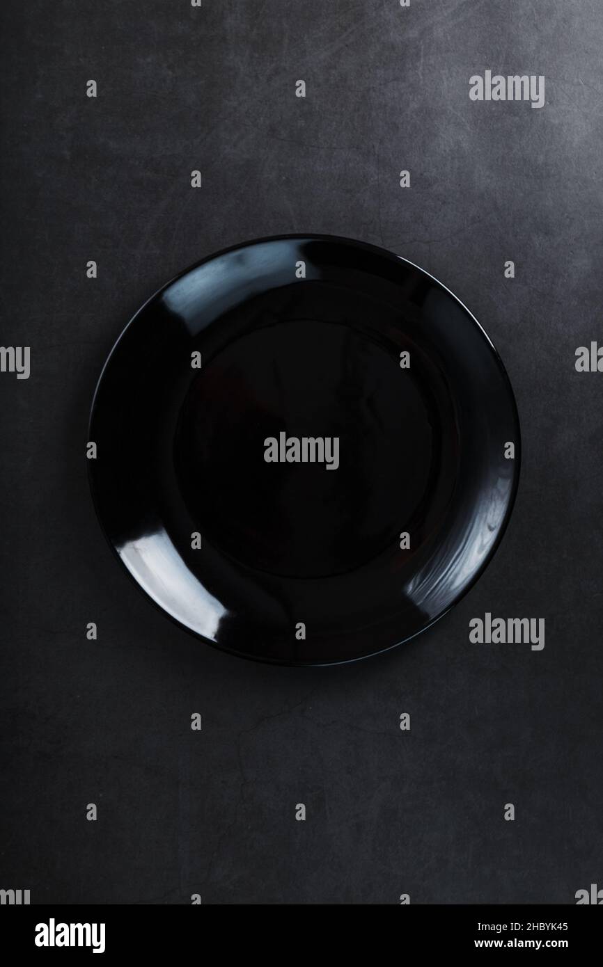 Black plate on a black background top view. Minimalistic concept Stock ...