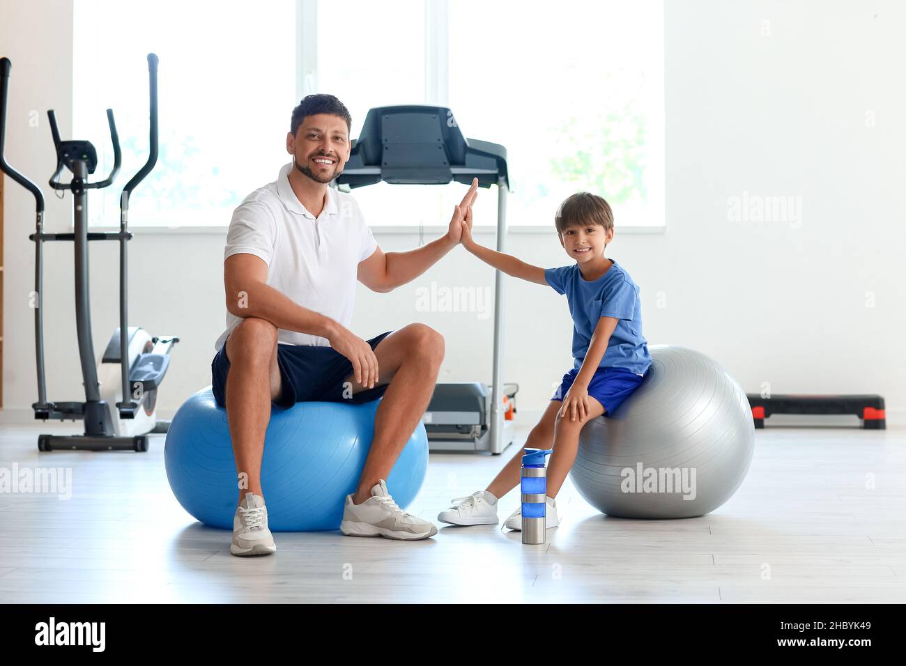 Male coach giving high-five to his little trainee in gym Stock Photo ...