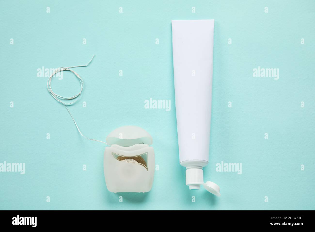 Dental floss and toothpaste on turquoise background Stock Photo - Alamy