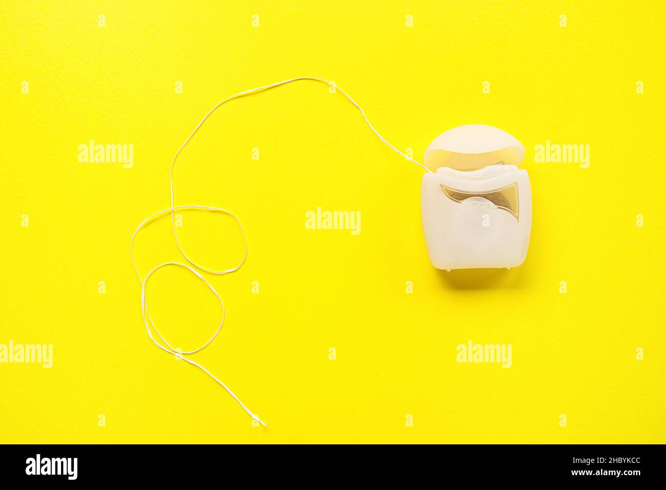 Dental floss on yellow background Stock Photo - Alamy