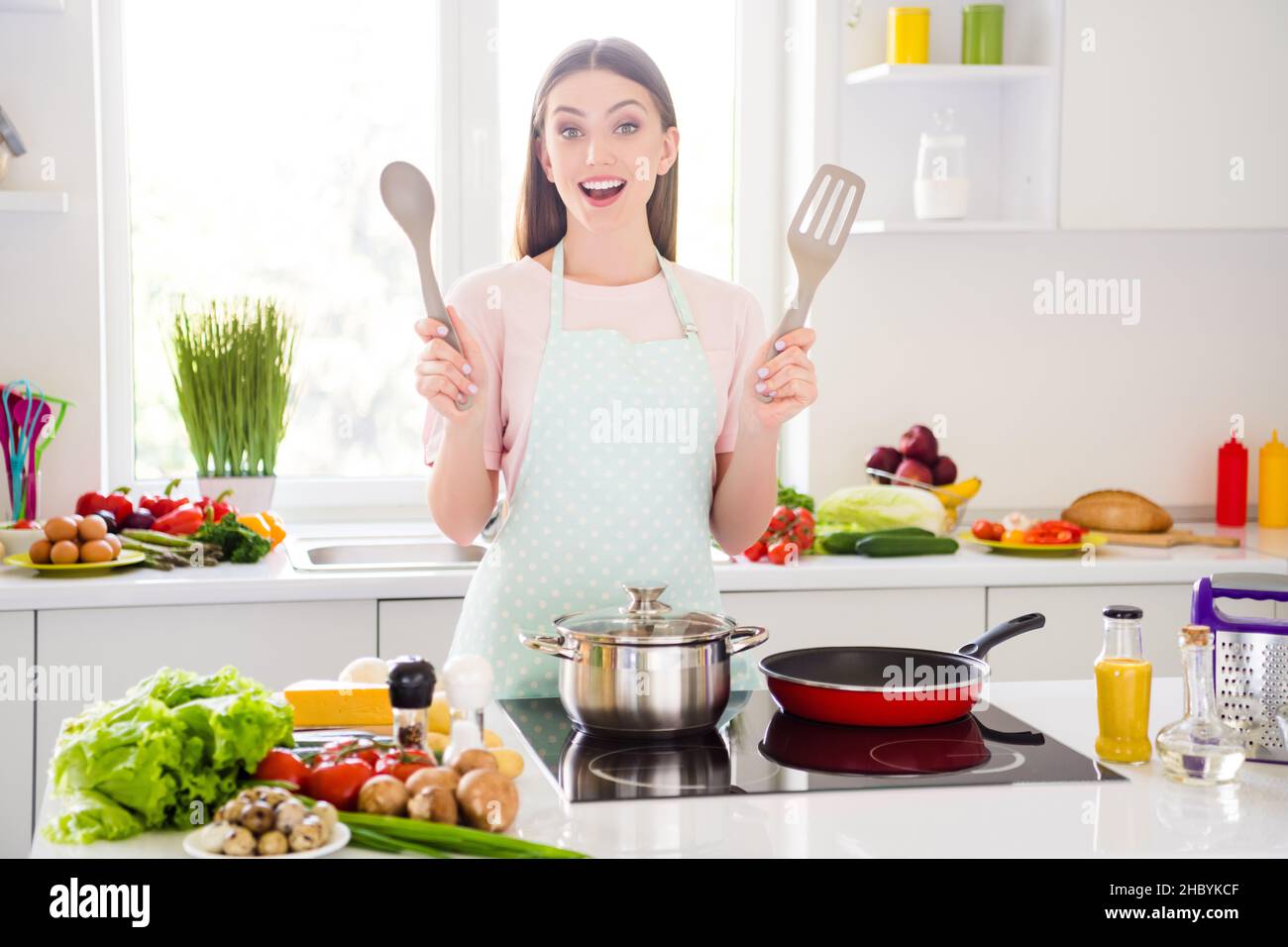 Portrait of attractive cheerful girl cooking fresh meal homemade salad ...