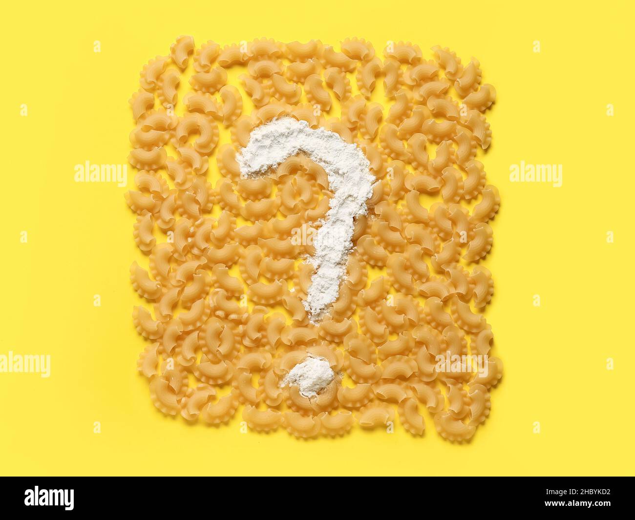 Question mark made of flour and dry pasta on yellow background Stock ...