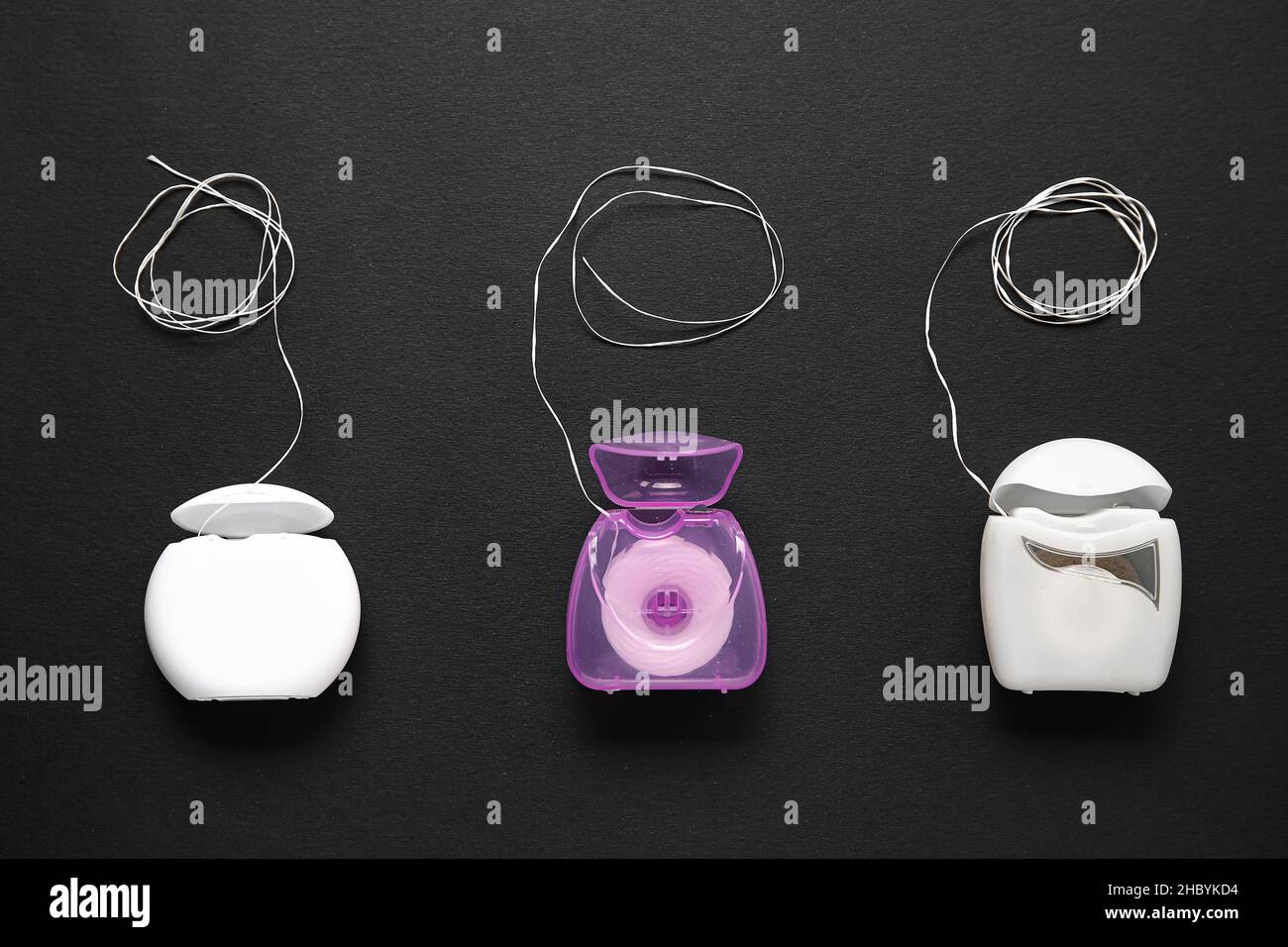 Different dental floss on black background Stock Photo - Alamy