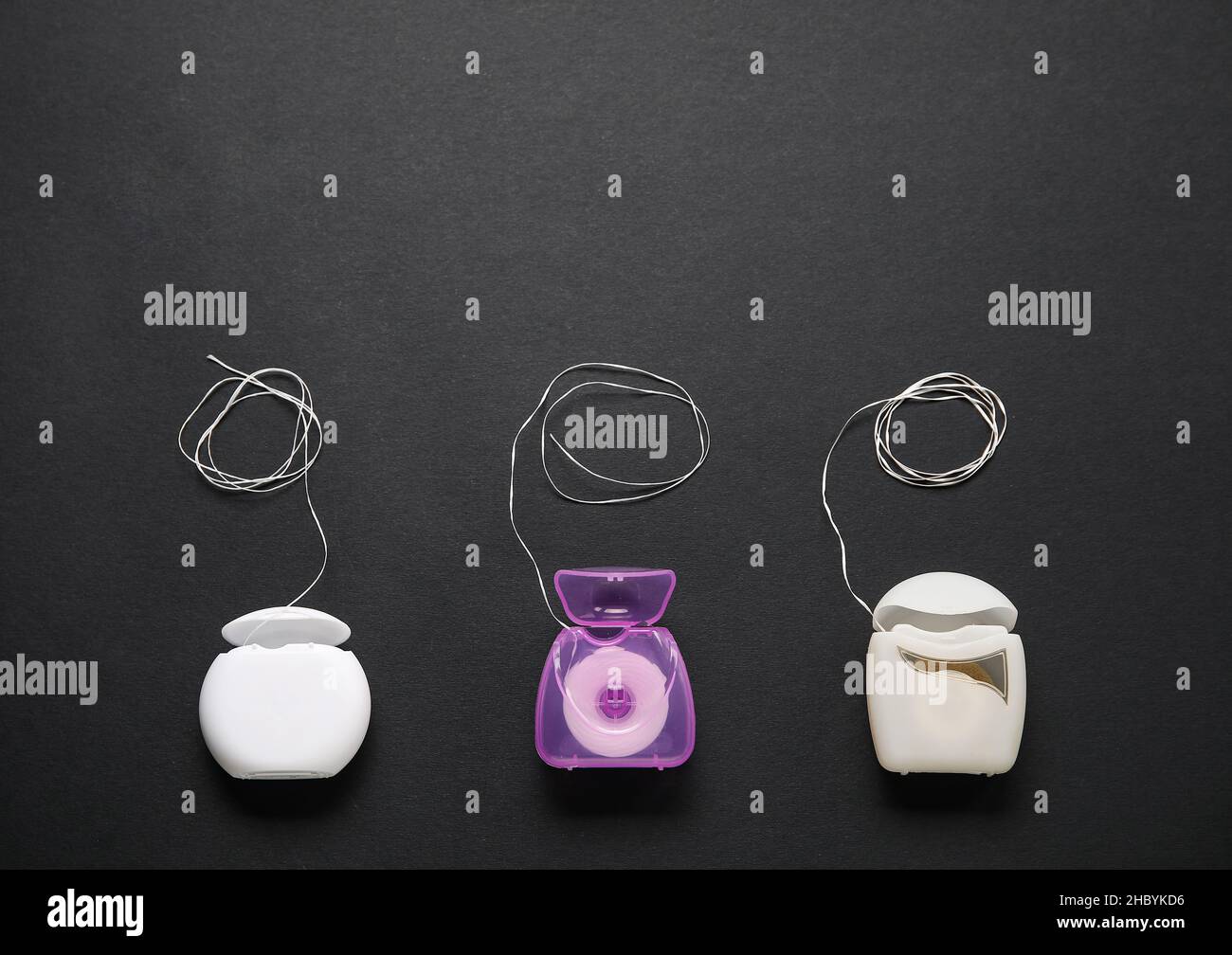 Different dental floss on black background Stock Photo - Alamy