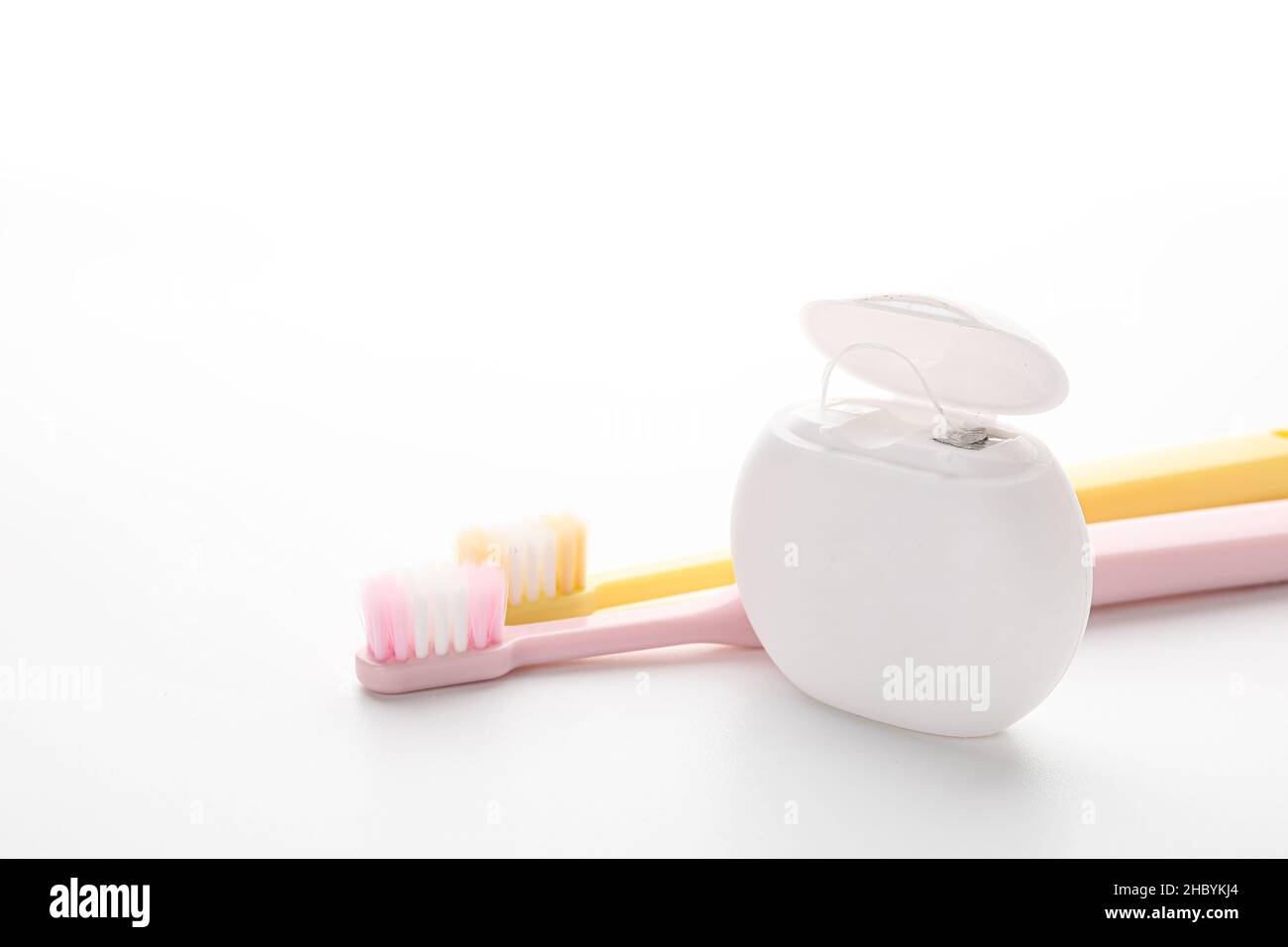 Dental floss and tooth brushes on white background Stock Photo - Alamy