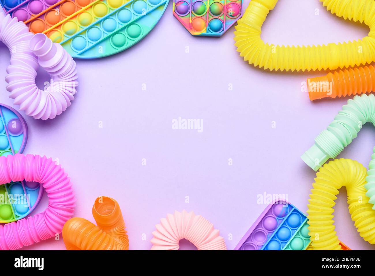 Frame made of colorful Pop Tubes and Pop it fidget toys on purple ...