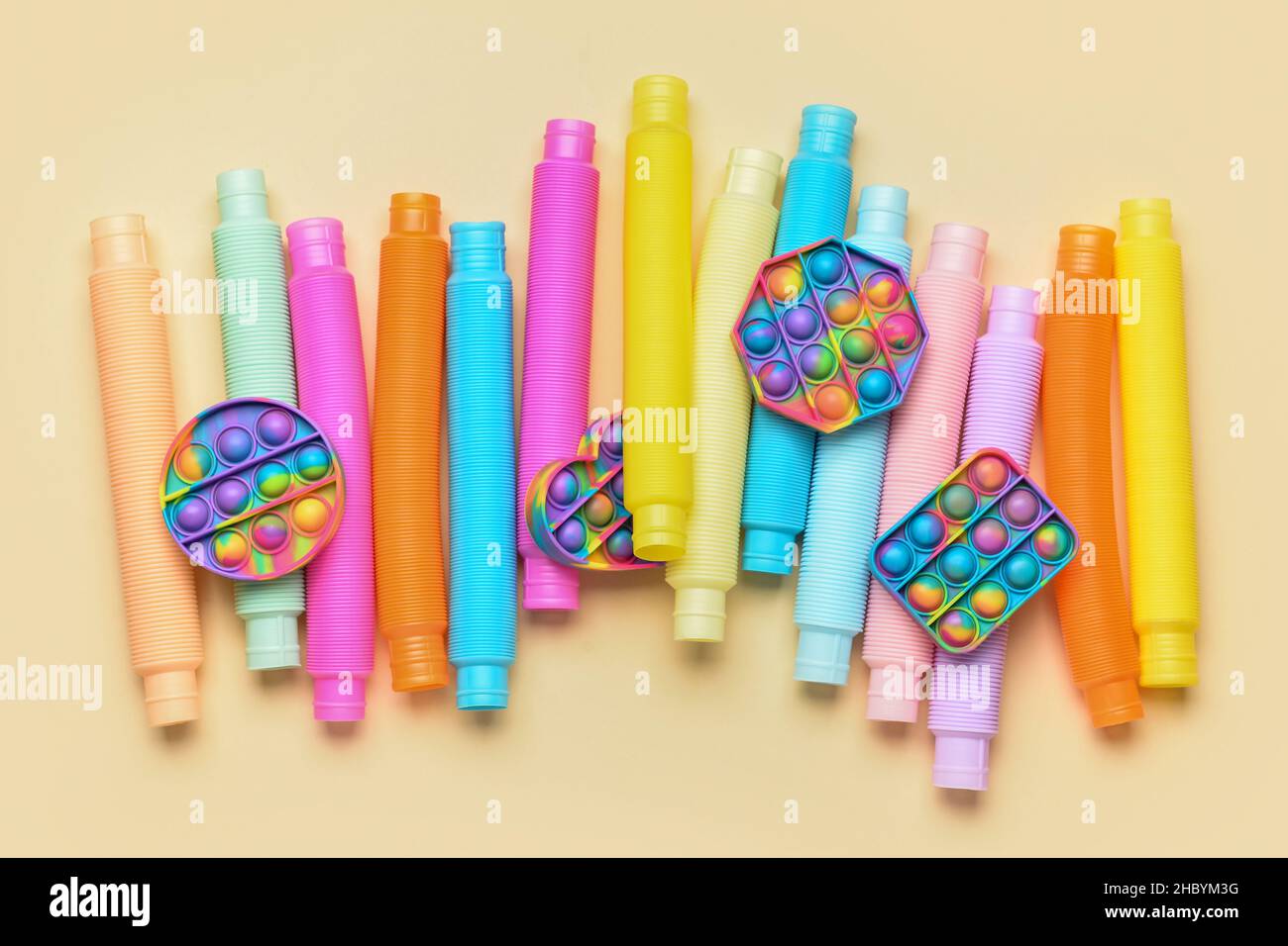 Colorful Pop Tubes and Pop it fidget toys on yellow background Stock ...
