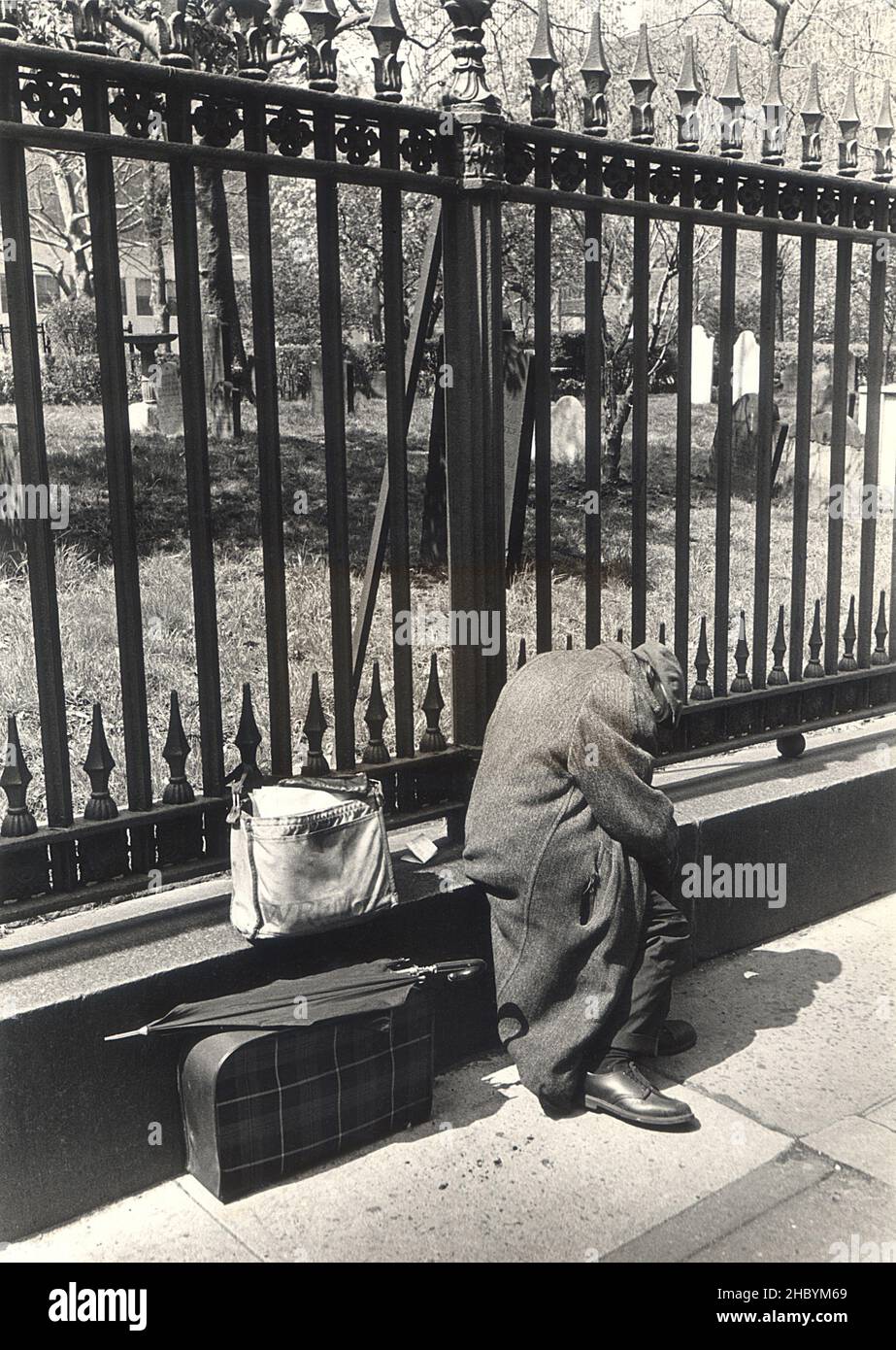 Homeless man with his belongings rests outside Trinity Church on lower ...