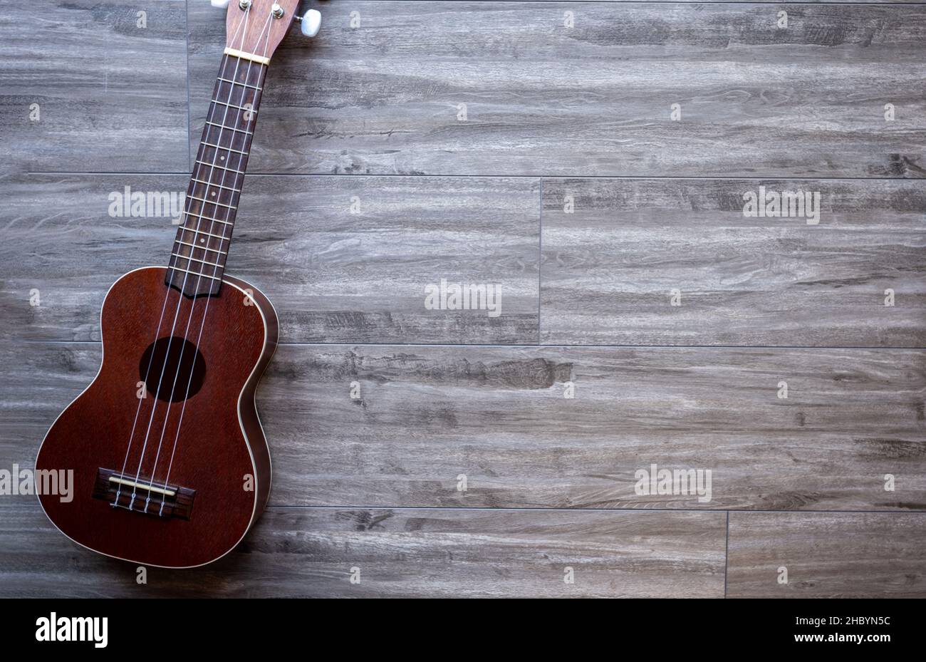 Ukulele guitar on gray wooden desk table for musician business ...
