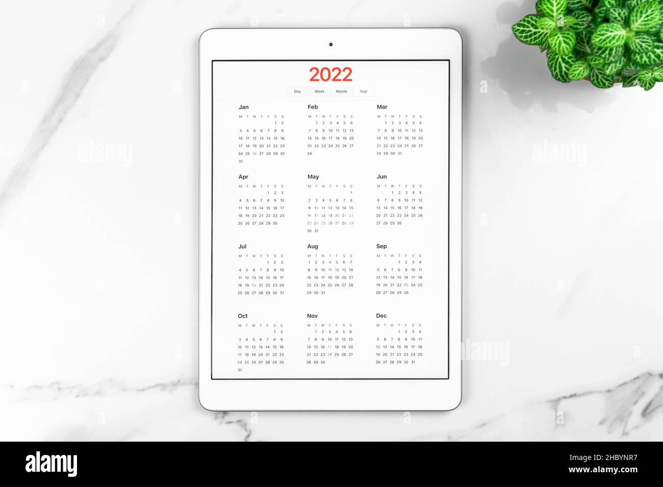 Calendar 2022. Tablet computer with open app. White marble background ...