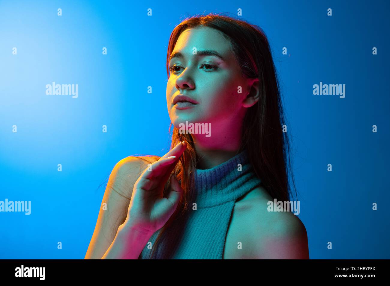 Beautiful female half-length portrait isolated on blue studio backgroud ...