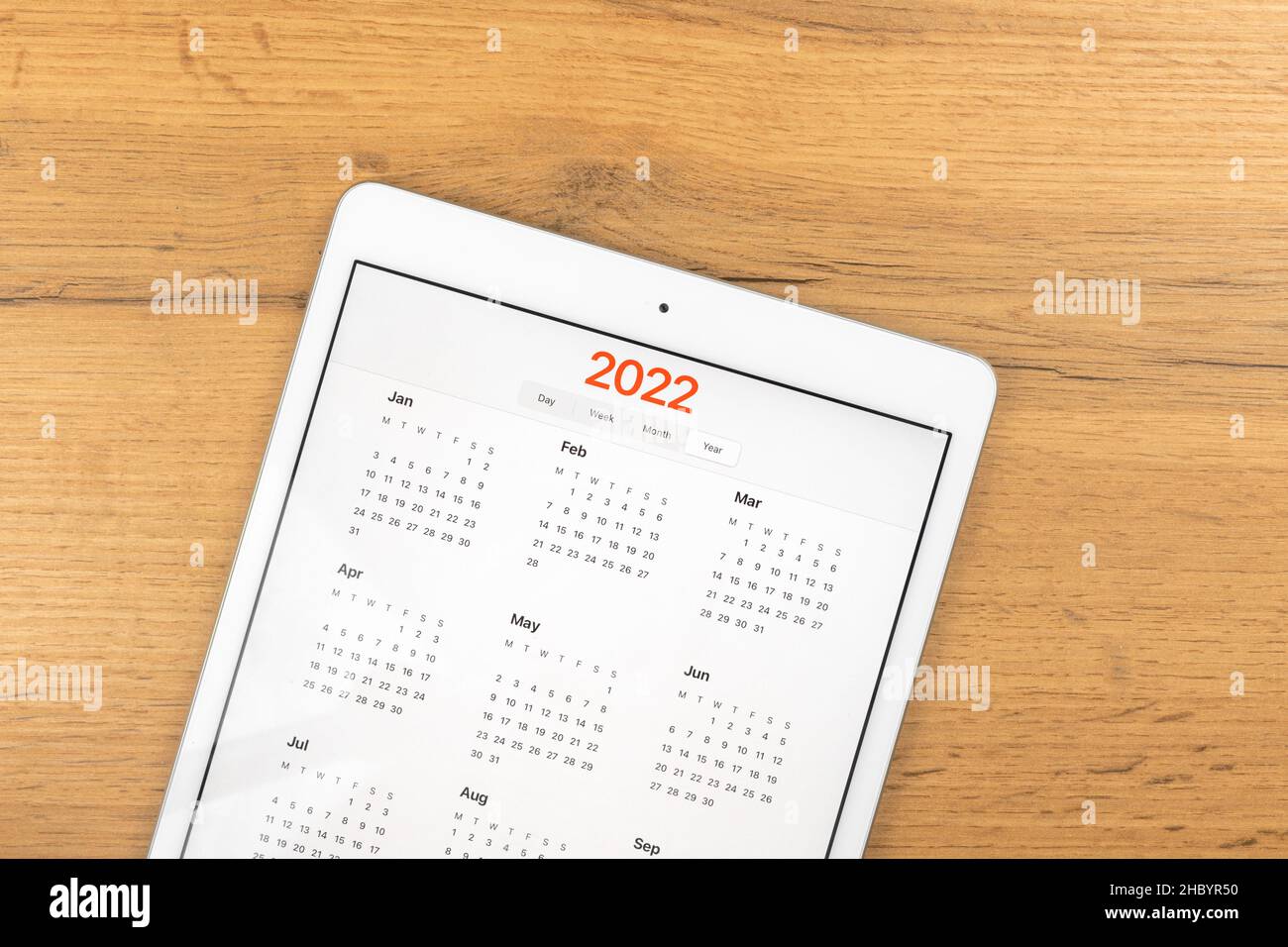 Calendar 2022 on the screen. Wooden table background, business desktop ...