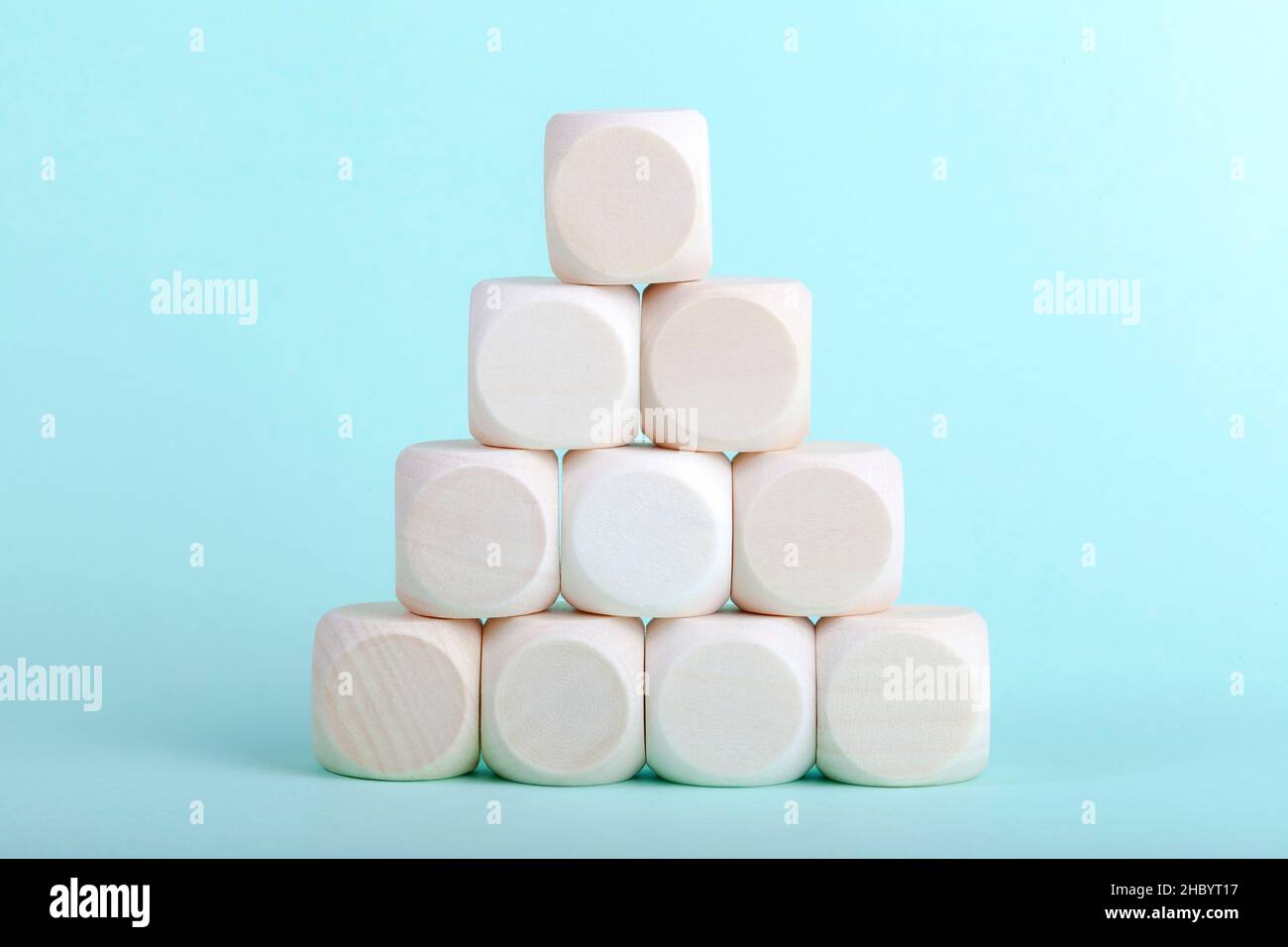 Simple pyramid made of small empty blank wooden blocks, cubes on light ...