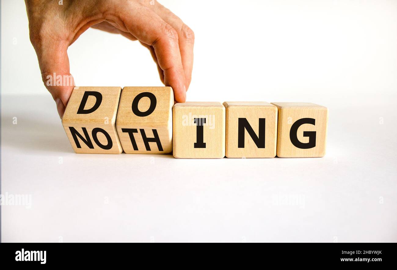 Doing or nothing symbol. Businessman turns wooden cubes and changes the ...