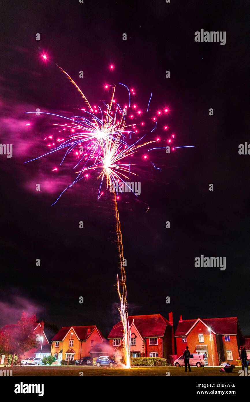 Firework display on village green with fireworks exploding on top of a ...