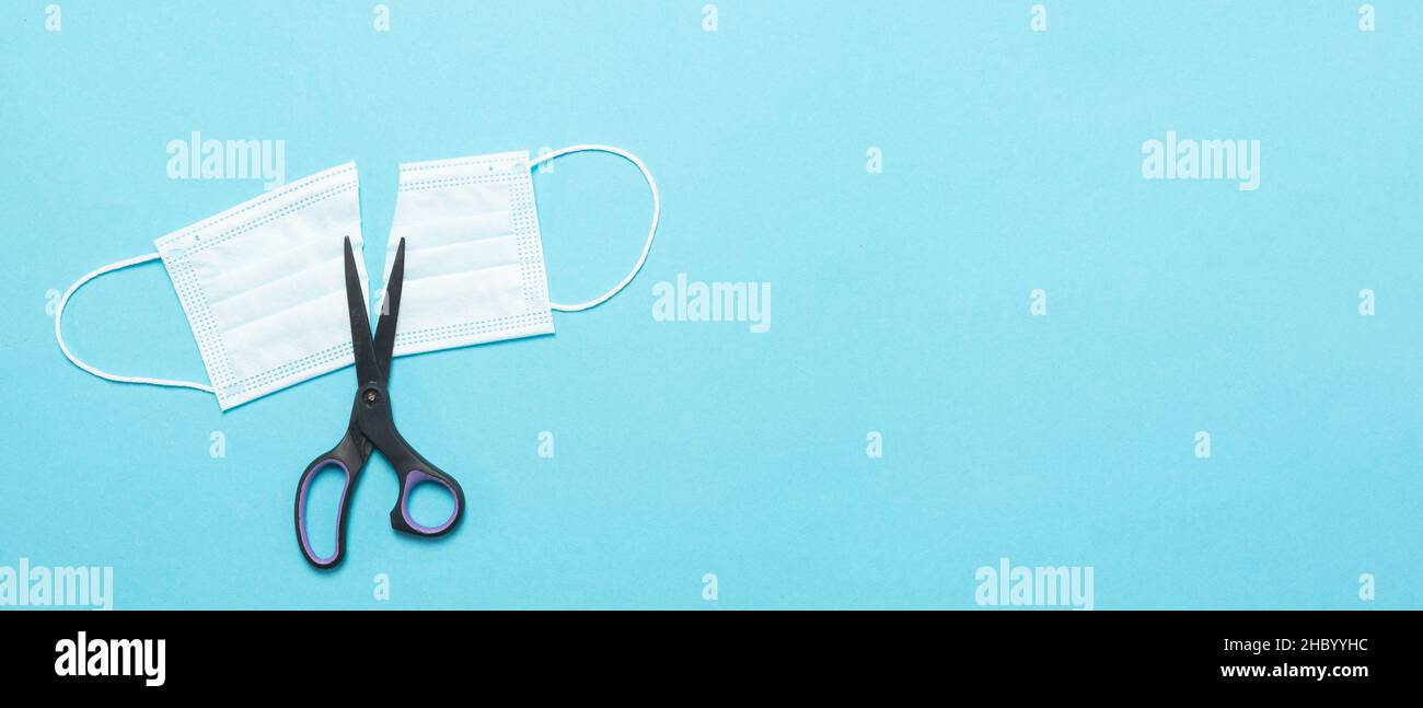 medical mask cut into 2 parts and scissors with space for text. View ...