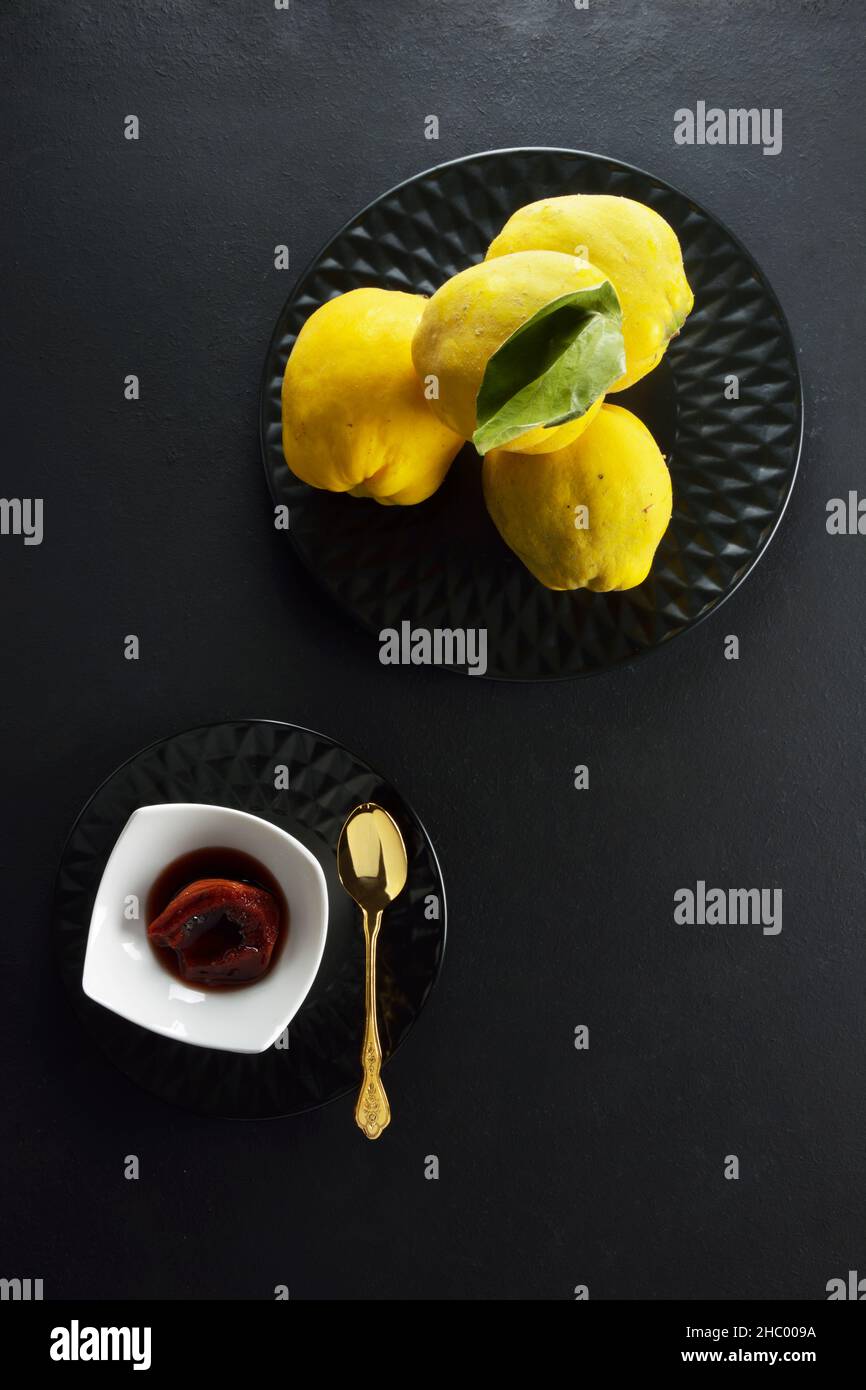 Raw quinces and baked quince on black background Stock Photo - Alamy