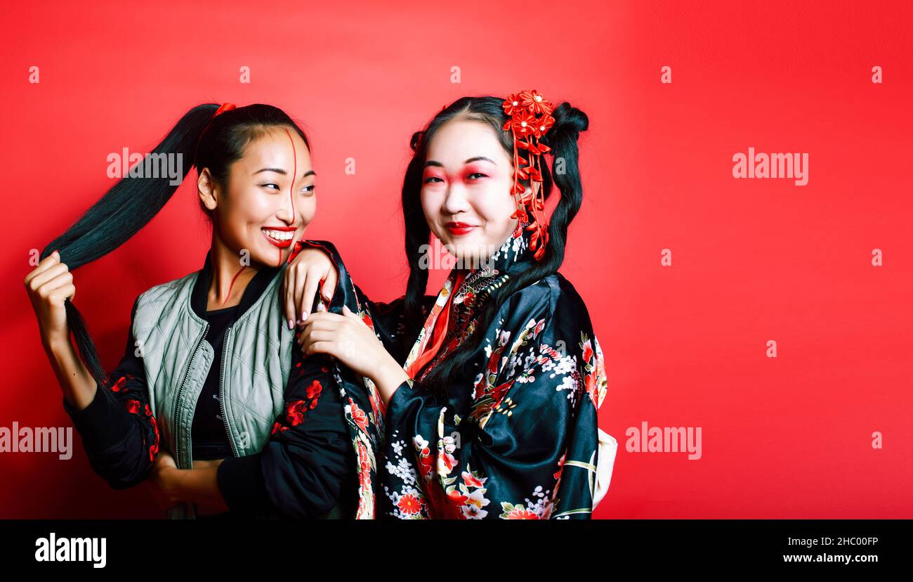 two pretty geisha friends: modern asian woman and traditional wearing ...