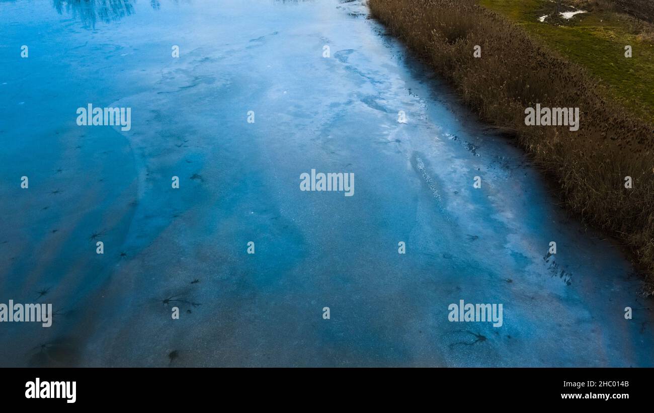 Blue pond is frozen over in autumn Stock Photo - Alamy