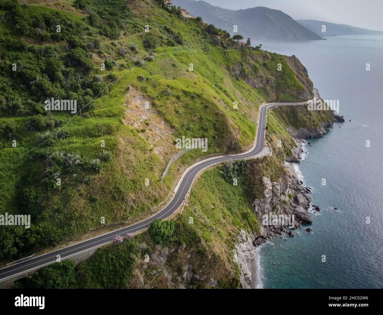 Aerial view of the SS113, a winding road on the edge of a rocky cliff ...