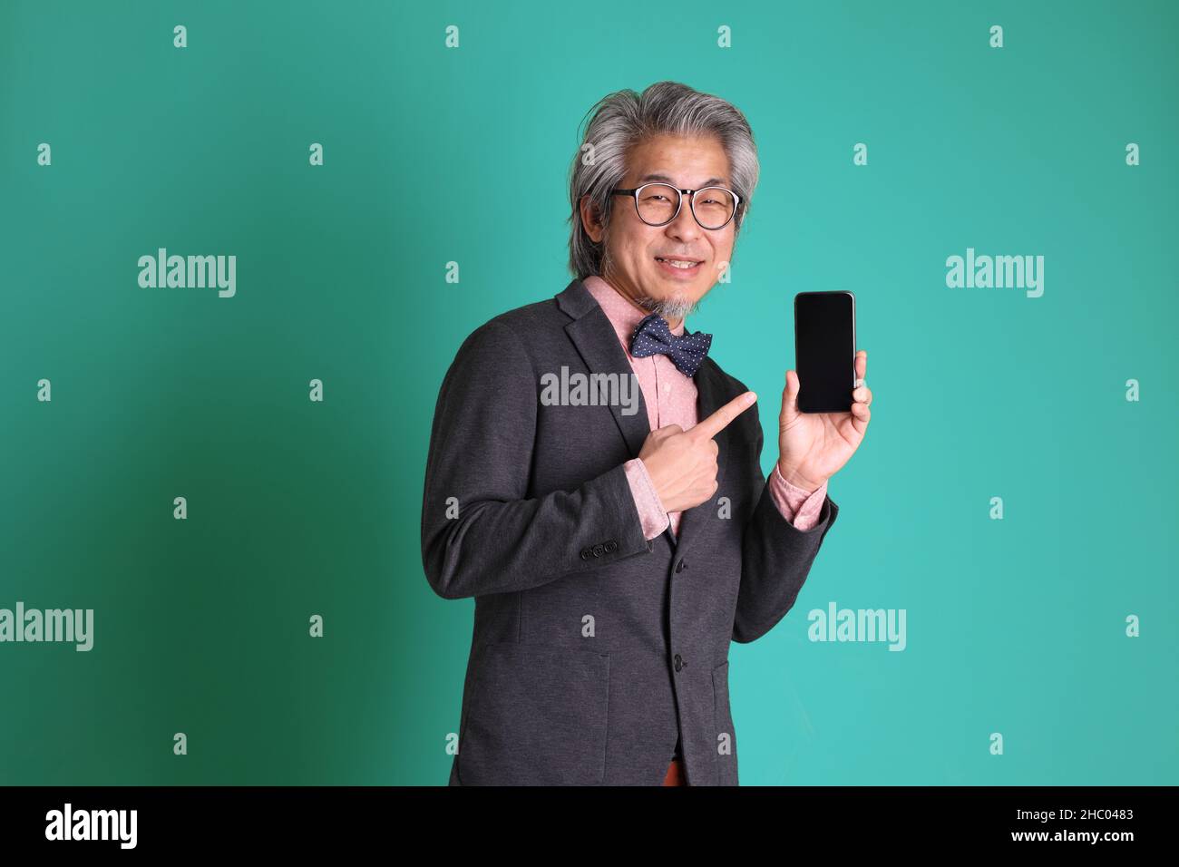 The senior Asian teacher standing on the green background Stock Photo ...