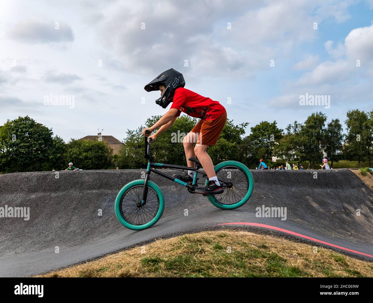 Boy riding a bicycle at opening event at Ormiston BMX pump track, East ...