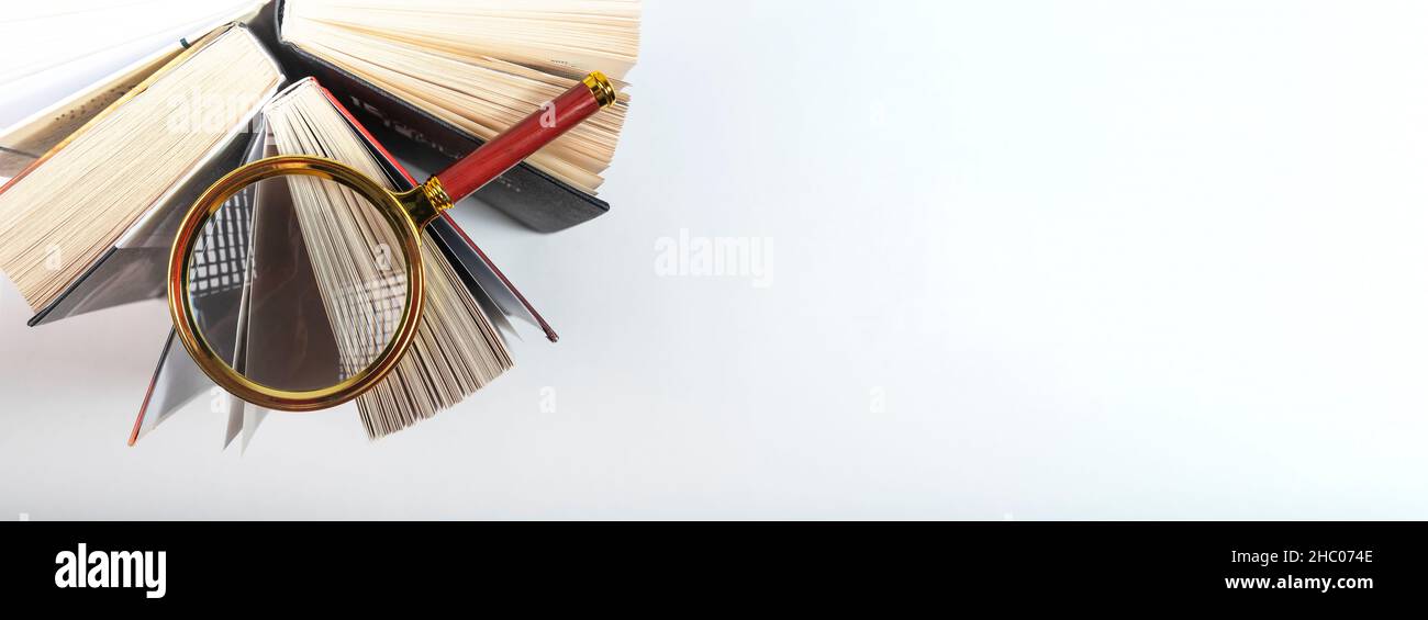 Magnifying glass over paper books on white background. Ad banner with ...