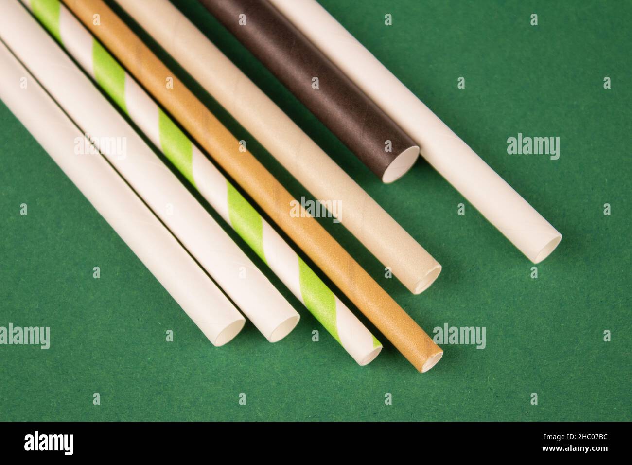 Set of different drinking paper straws on green background ...