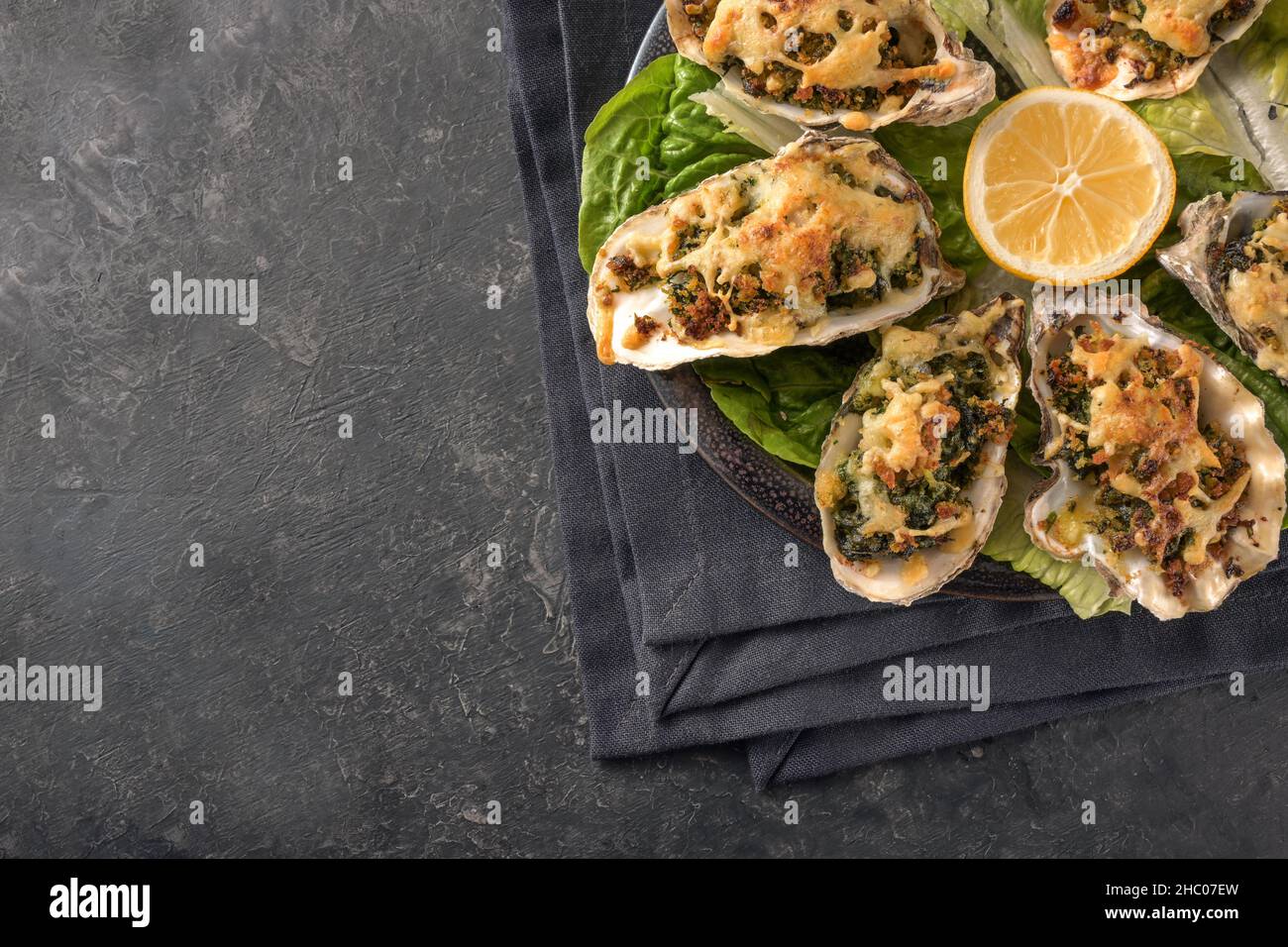 Oysters Rockefeller style baked with spinach and cheese on a plate with ...