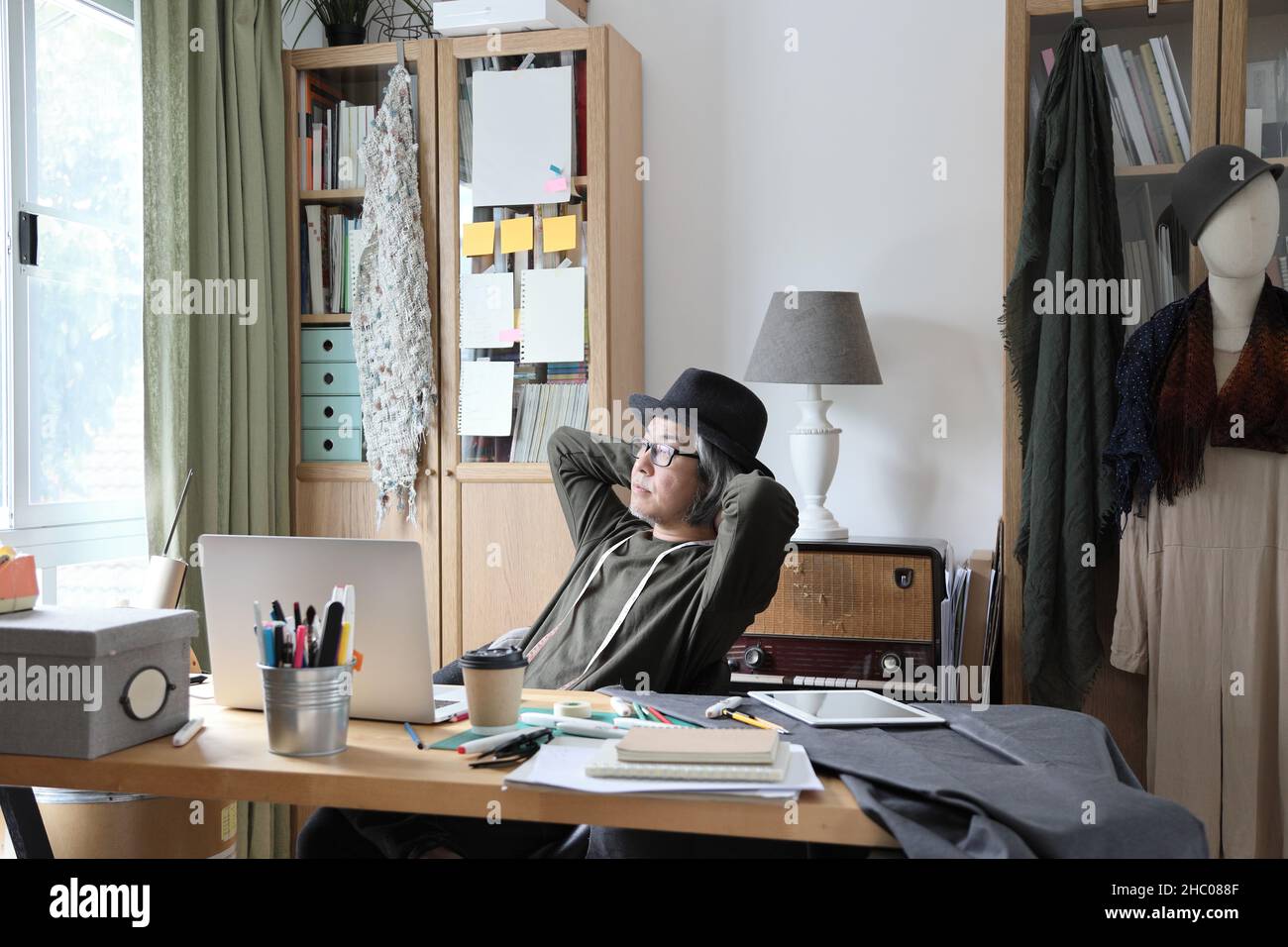 The senior Asian designer working in the studio Stock Photo - Alamy