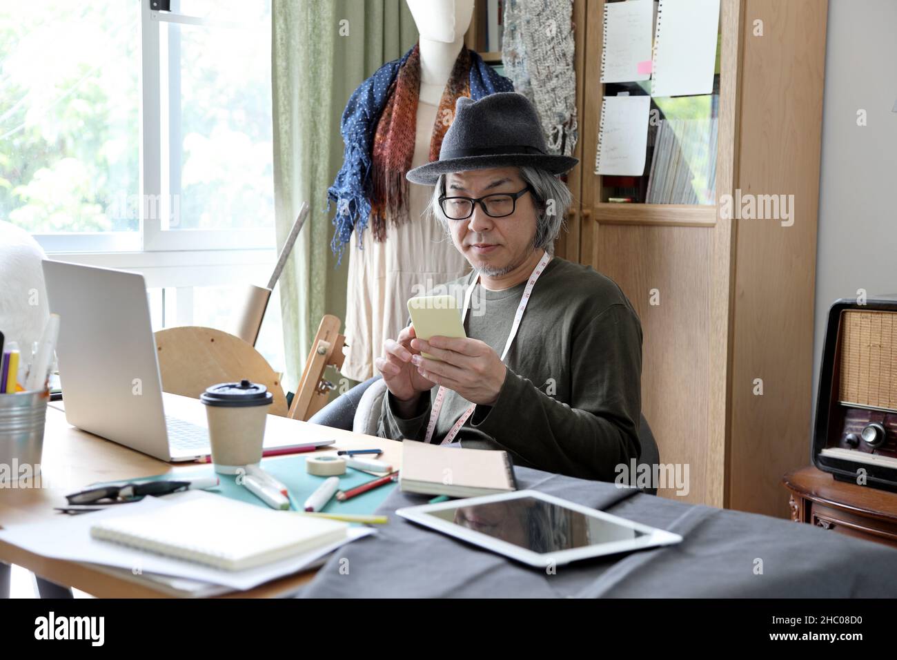 The senior Asian designer working in the studio Stock Photo - Alamy