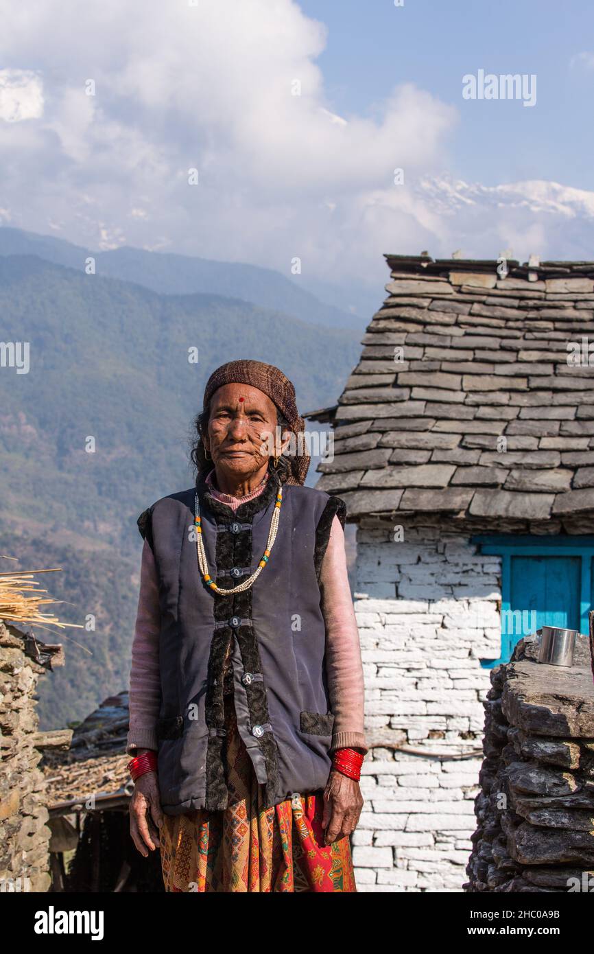 An older Nepali Hindu woman in traditional dress in front of her farm ...