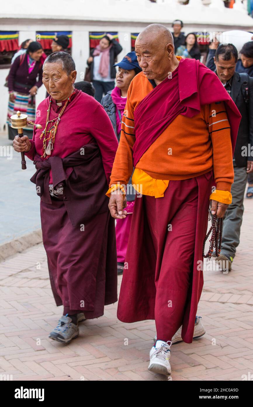 A Buddhist monk and nun with mala rosary beads and prayer wheel ...