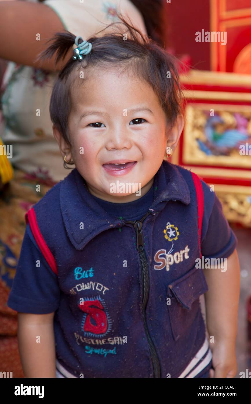 A young Nepali toddler smiles and laughs at the photographer in ...
