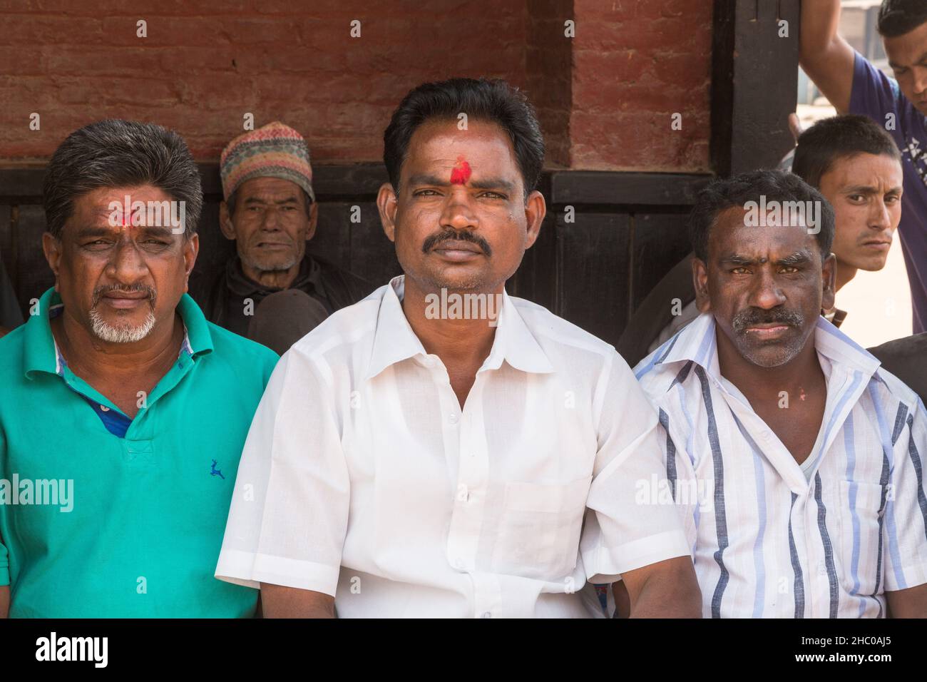 A group of Nepali men sit in the shade in the medieval city of ...