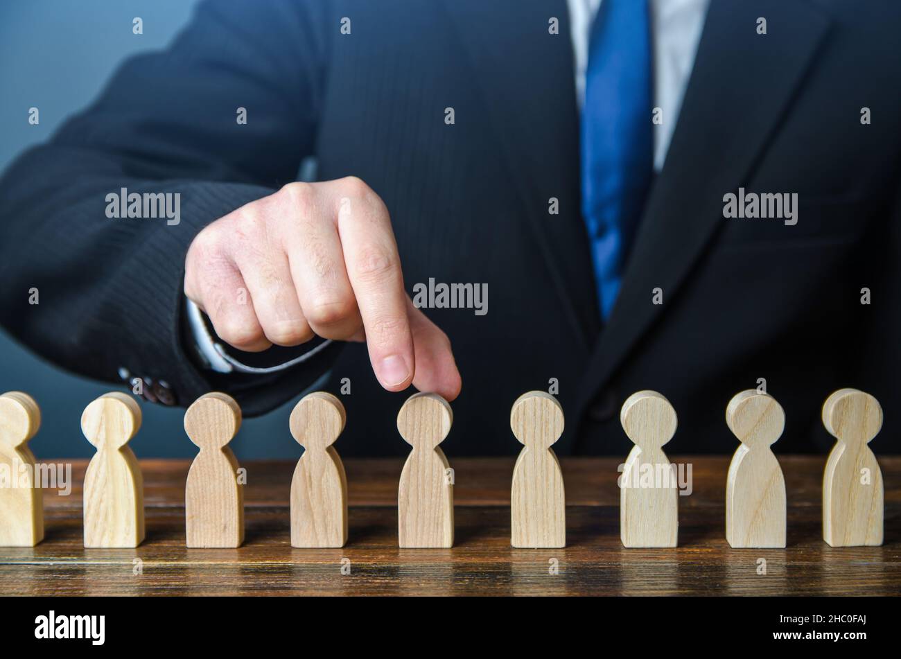 A businessman chooses a person from a row. Recruiting. Headhunter HR ...