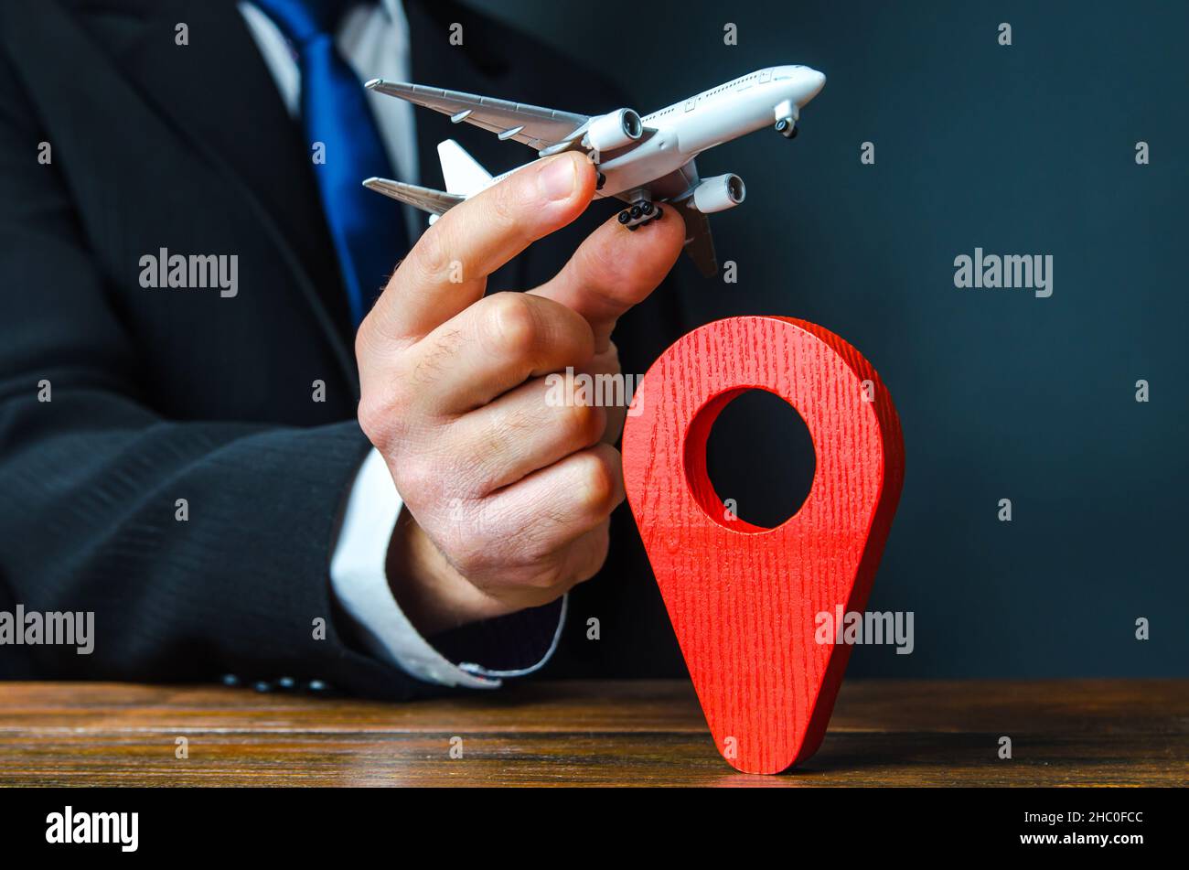 A plane taking off in the hands of a businessman and a pin location ...