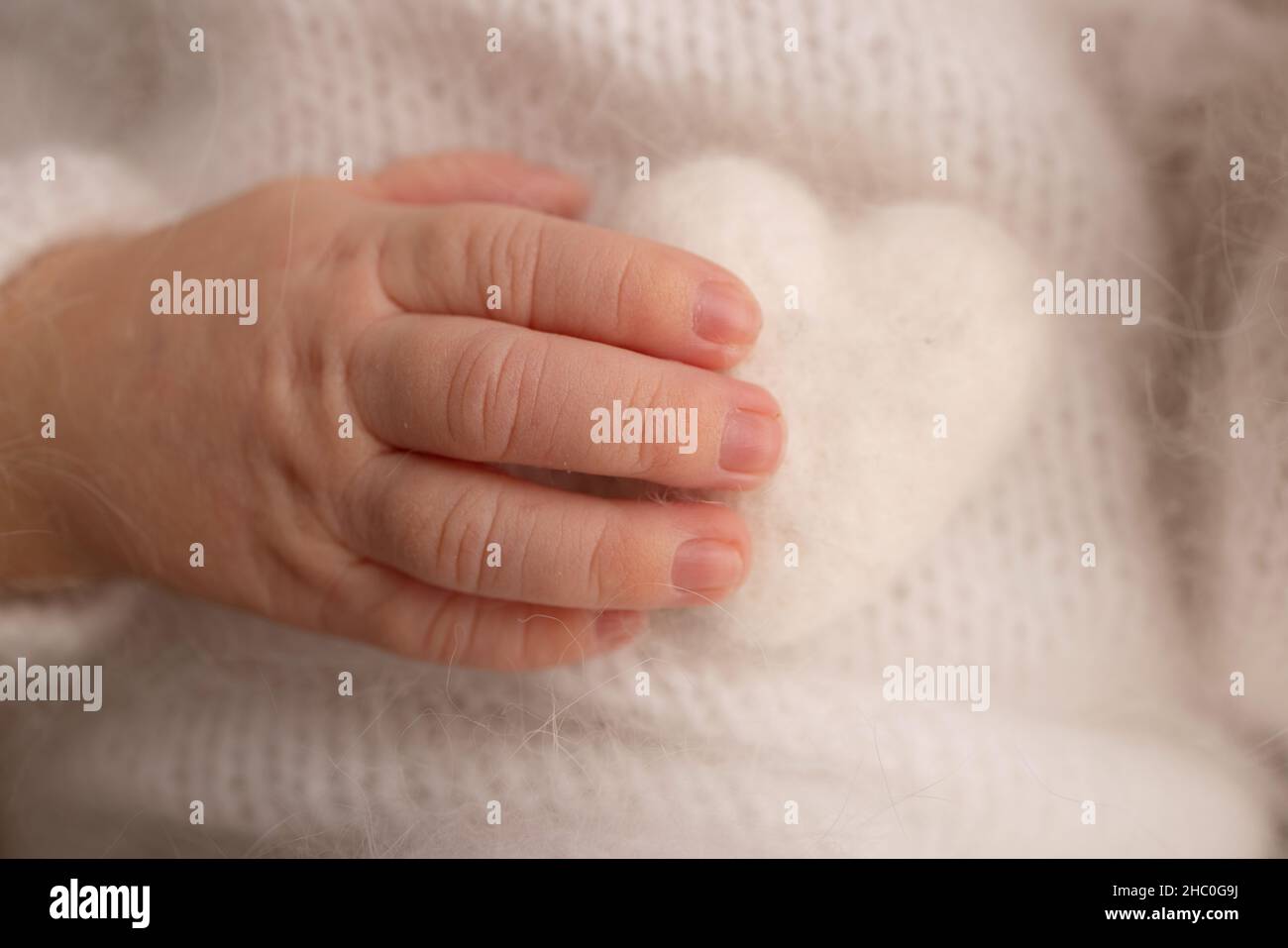 Tiny hand of a newborn baby. Soft hands of new born in white clothes ...
