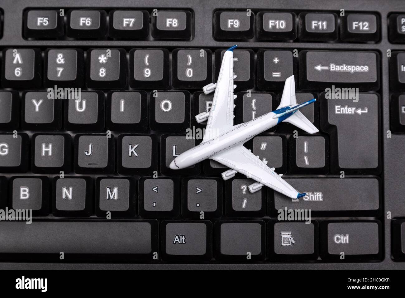 Model of the airplane on a computer keyboard. Buying air tickets online ...