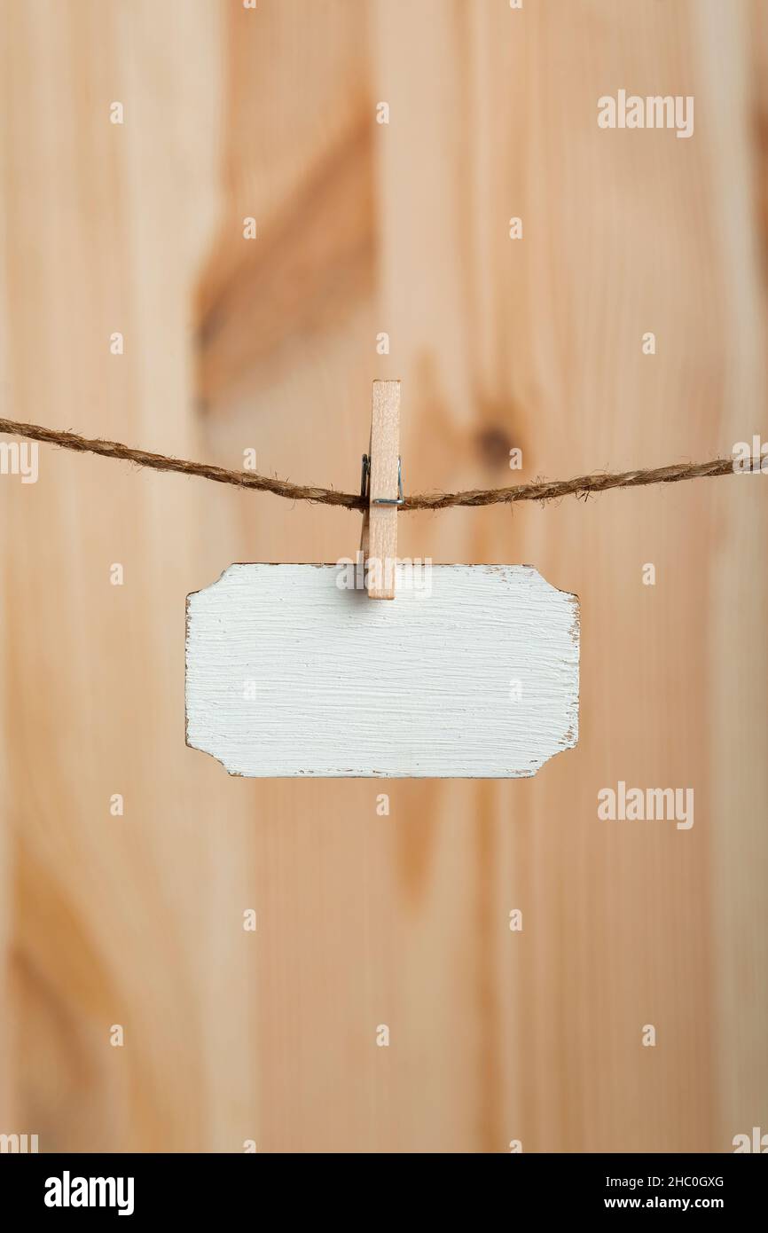 Blank wooden sign hang with clothespins on rope on wooden background ...