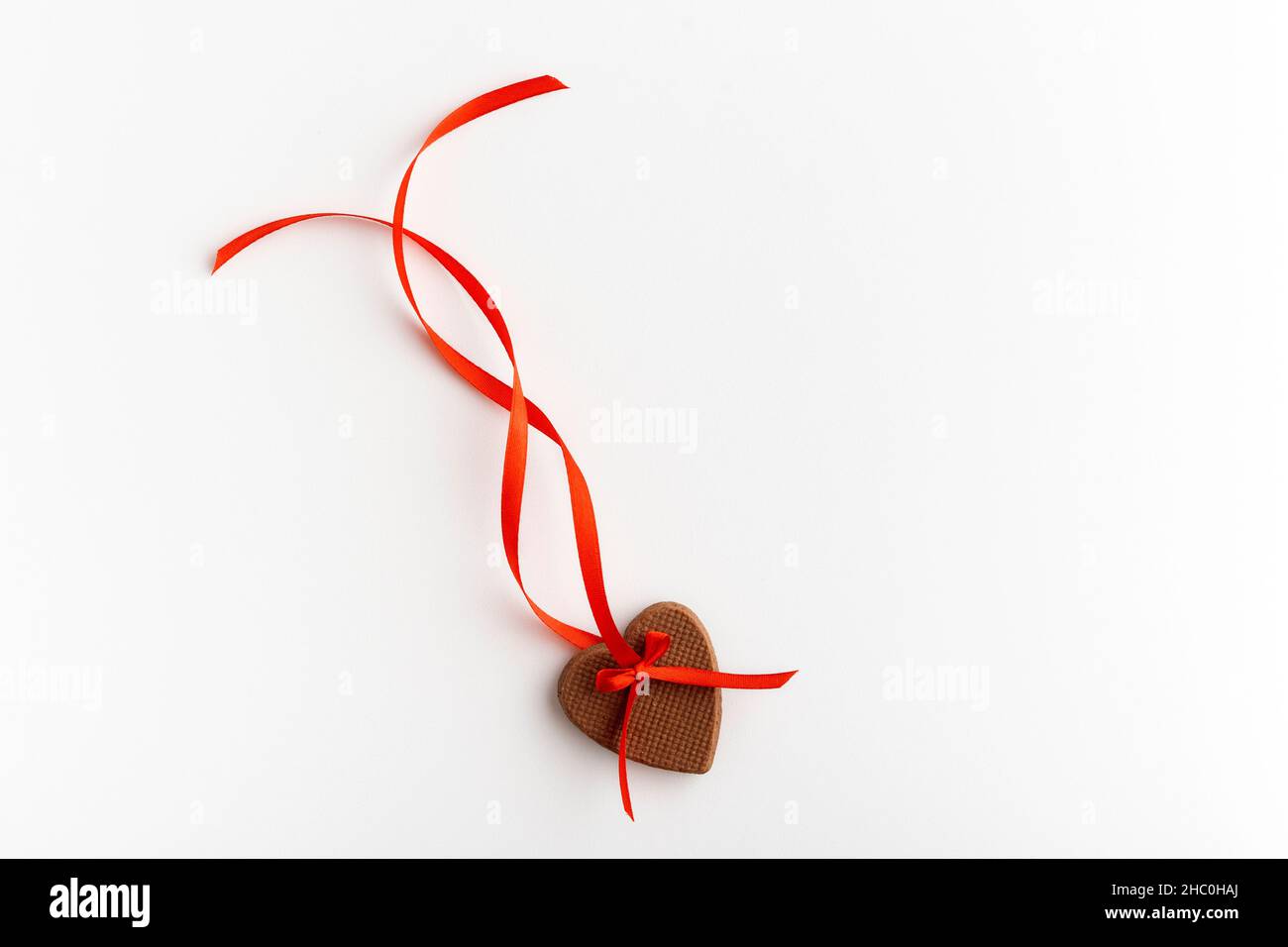 Heart shaped cookie with red ribbon on over white background ...
