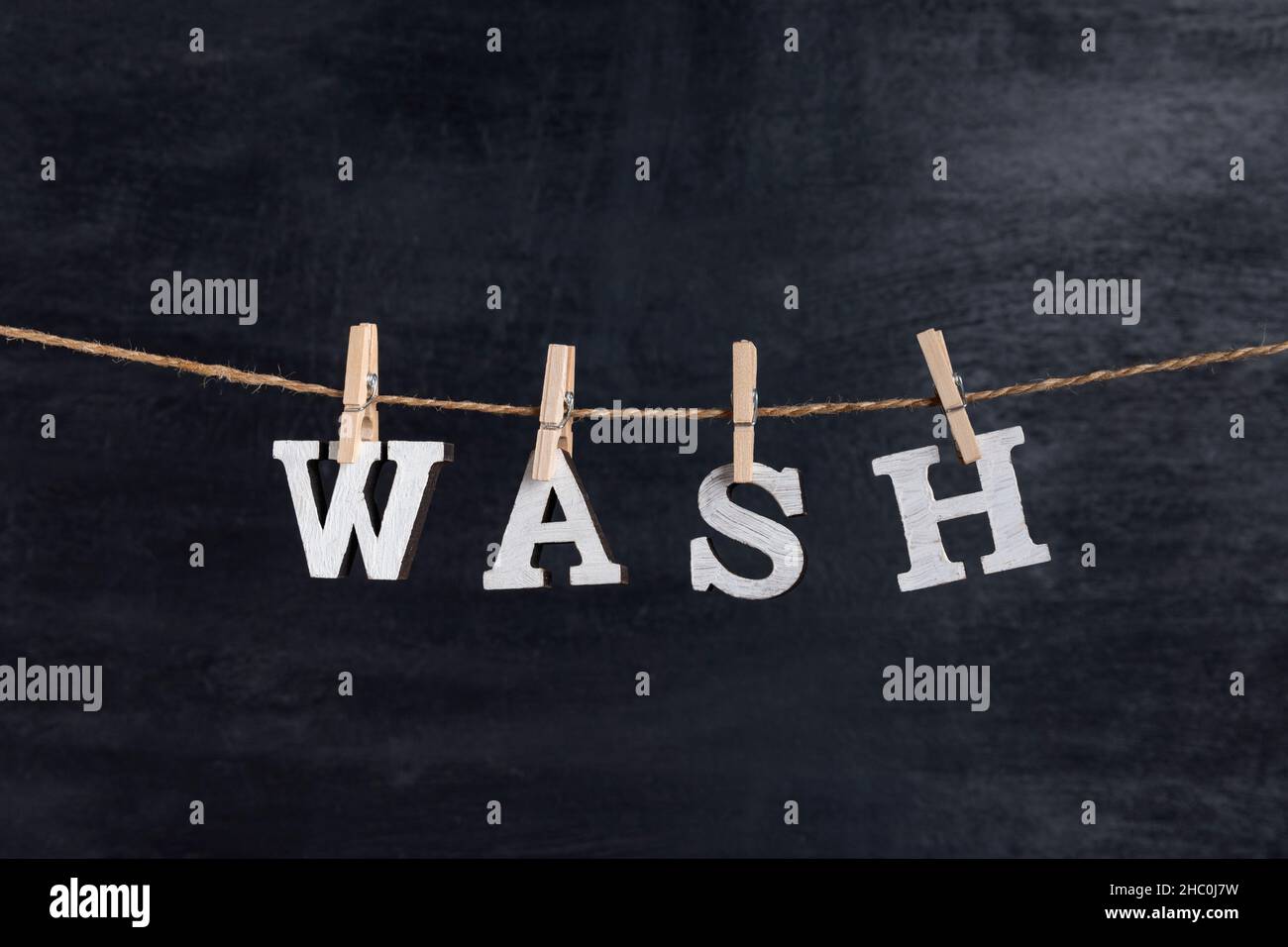Word WASH with clothespins on black background. Concept of laundry ...