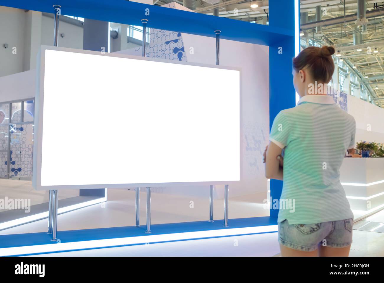 Woman looking at blank white display wall at exhibition - white screen ...