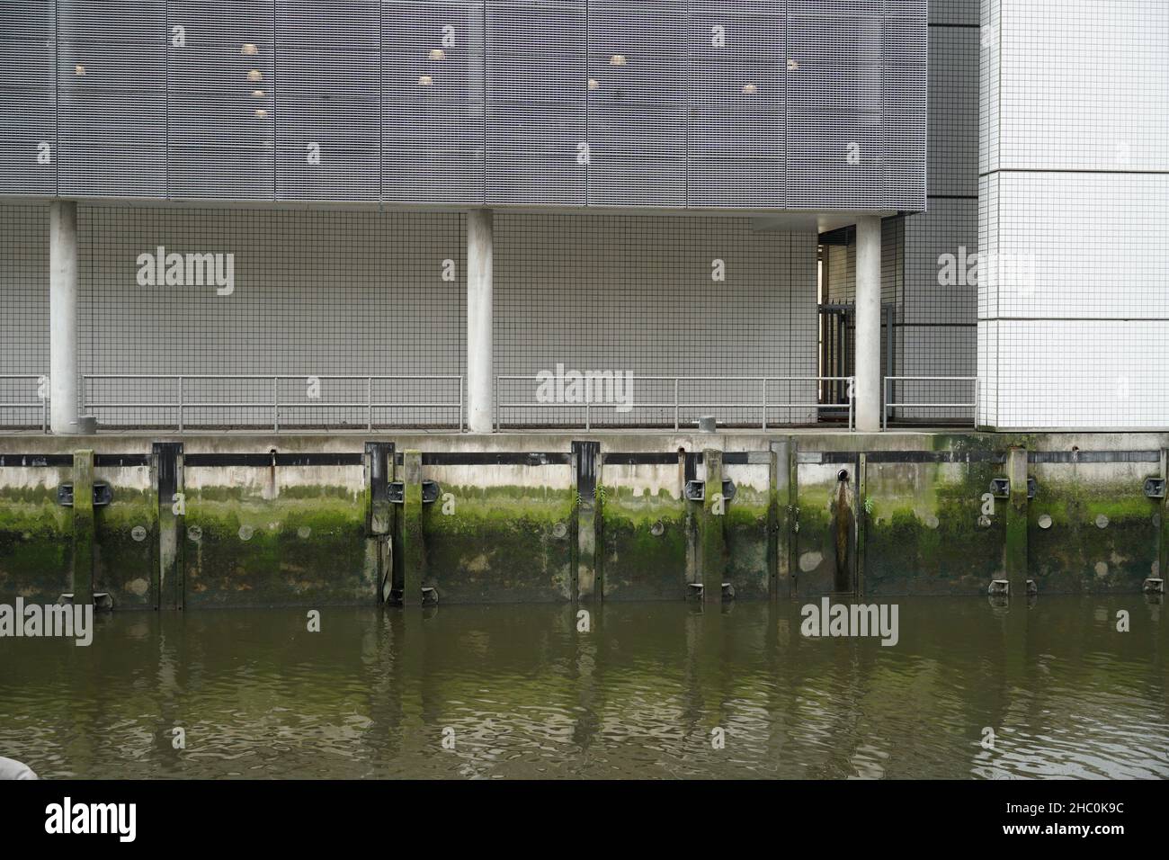 Corporate building above a concrete wall of riverbank in one channel of ...