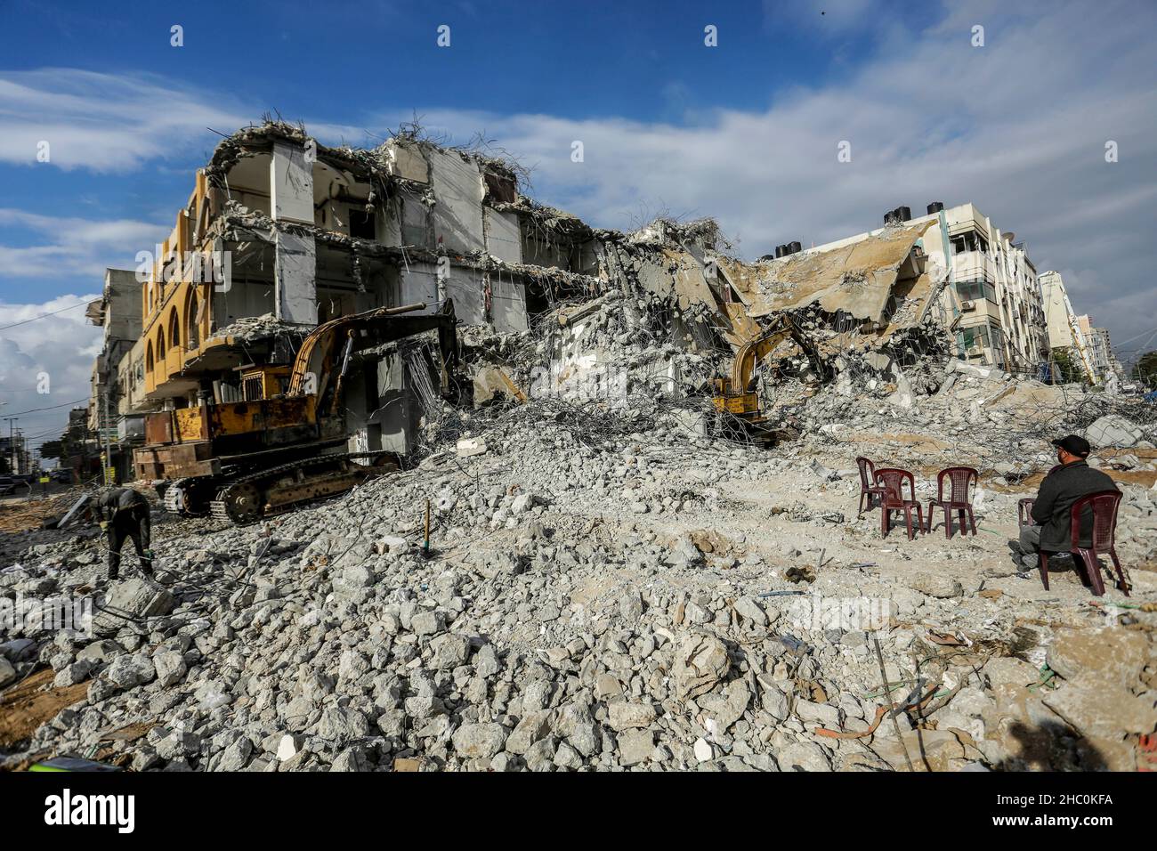 A bulldozer removes debris of Al-Jawharah Tower that was hit by Israeli ...