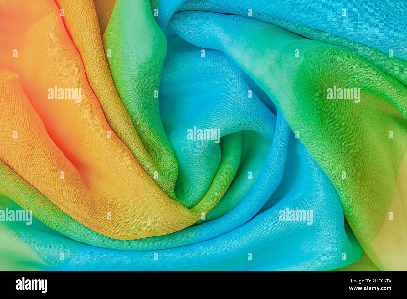 Multicolored soft silk fabric texture in spiral shape closeup, abstract ...