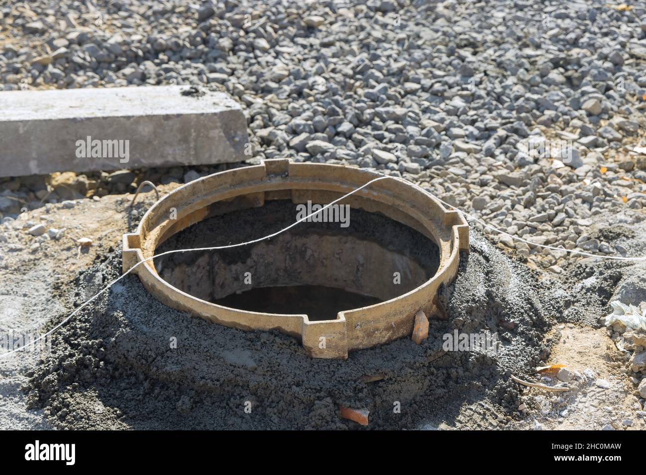 Sewerage construction with utility worker installing underground well ...